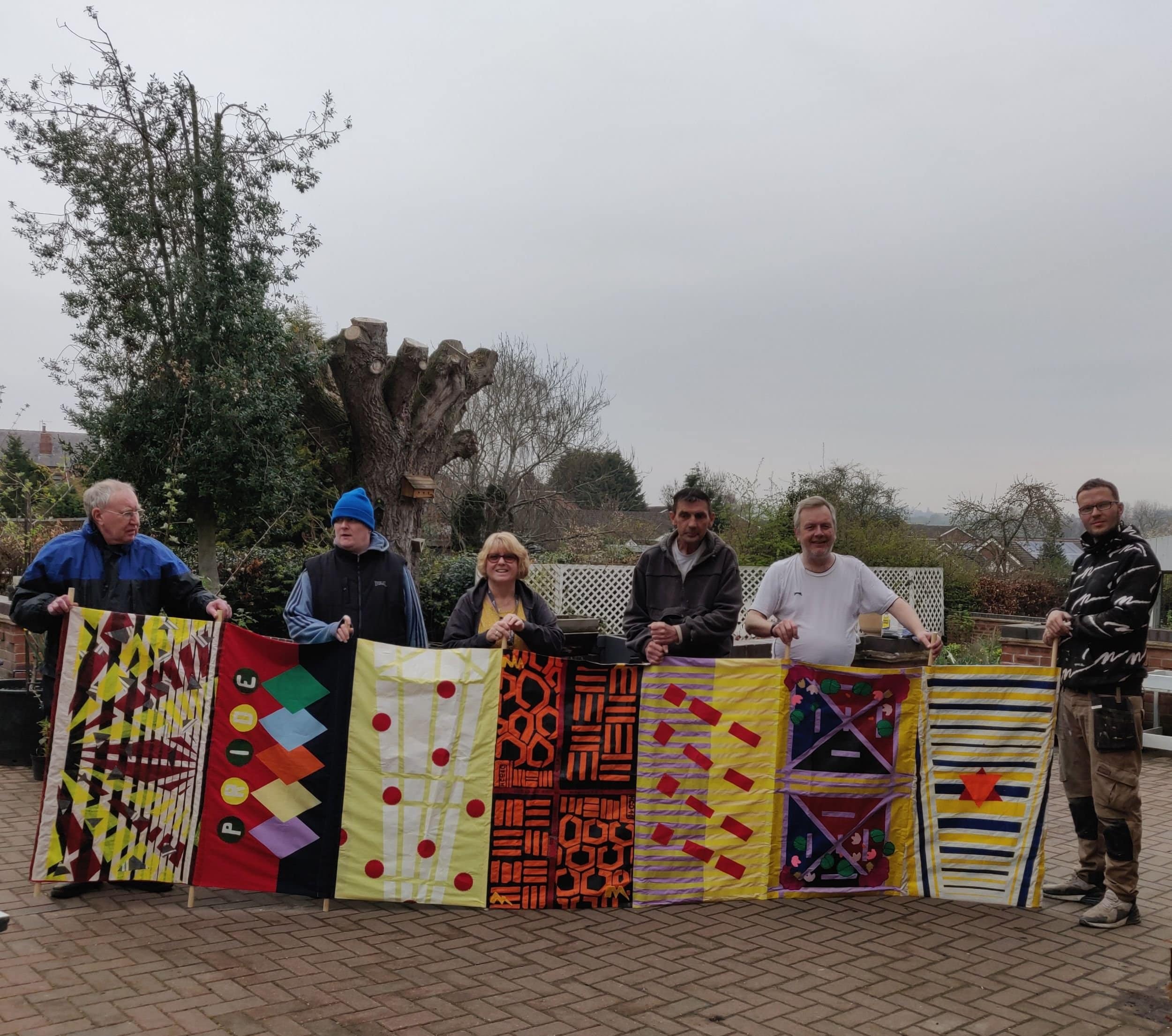 First-time artists from Derventio Housing Trust putting up the banner ...